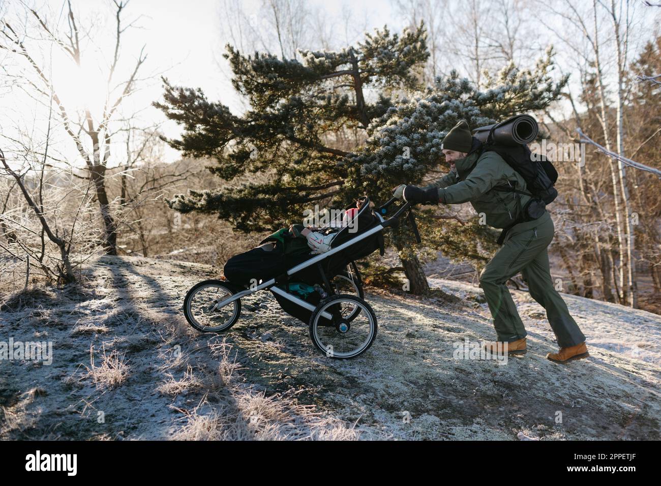 Man pushing pram uphill at winter Stock Photo - Alamy