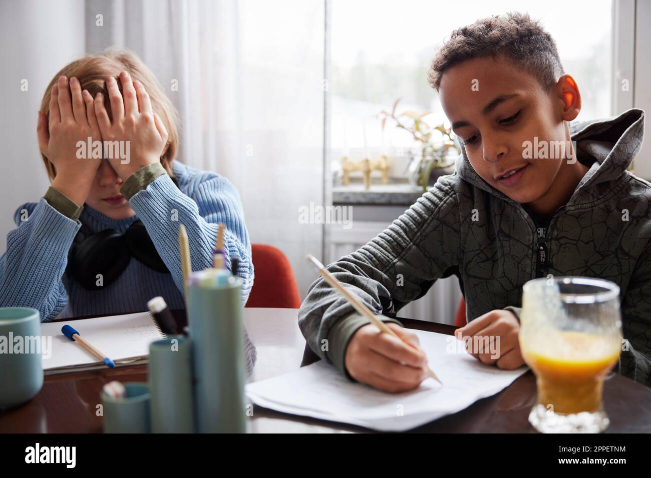 Two boys doing homework at dining table Stock Photo - Alamy
