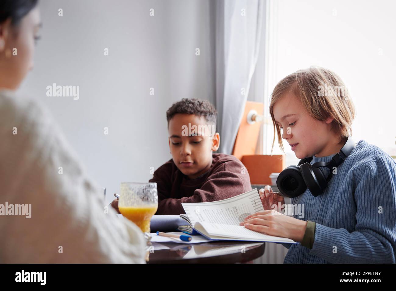 Two boys doing homework at dining table Stock Photo - Alamy