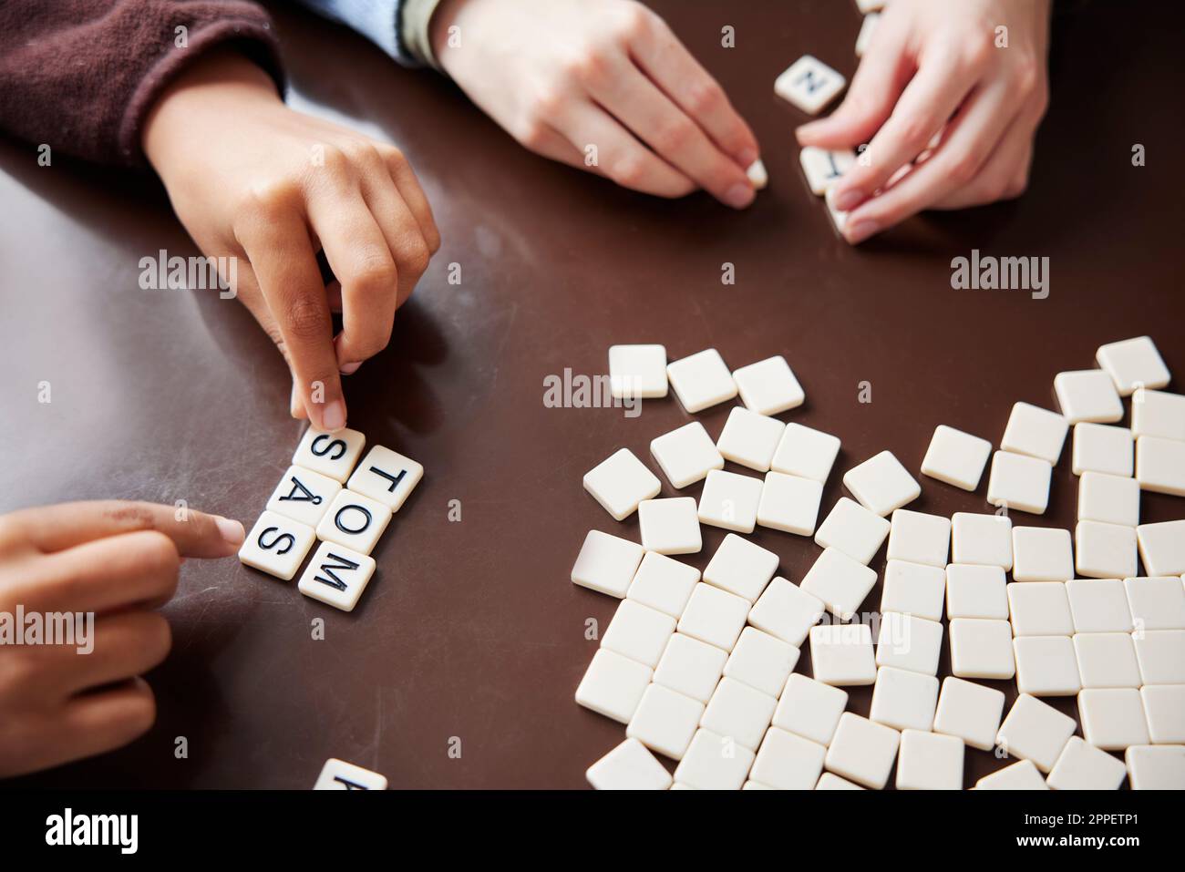 Children playing scrabble at dining table Stock Photo - Alamy