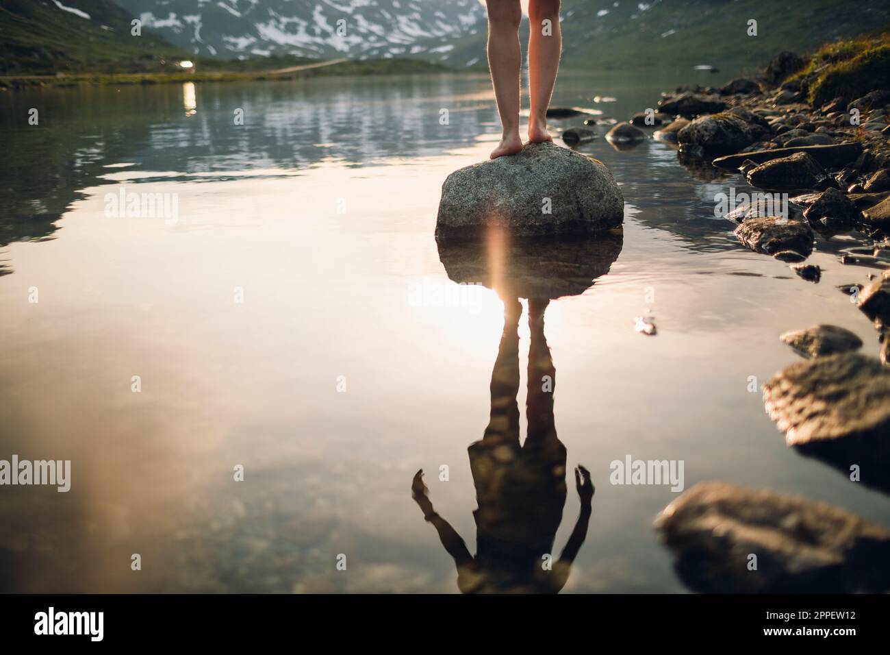 Low section of person standing on rock at lake Stock Photo - Alamy