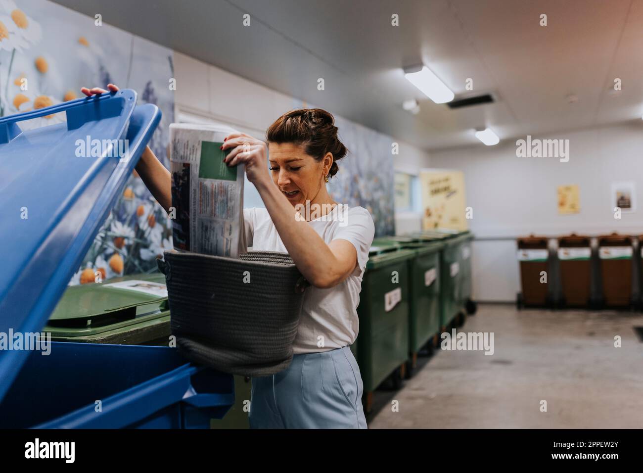 Smiling woman putting recycling into bins Stock Photo - Alamy