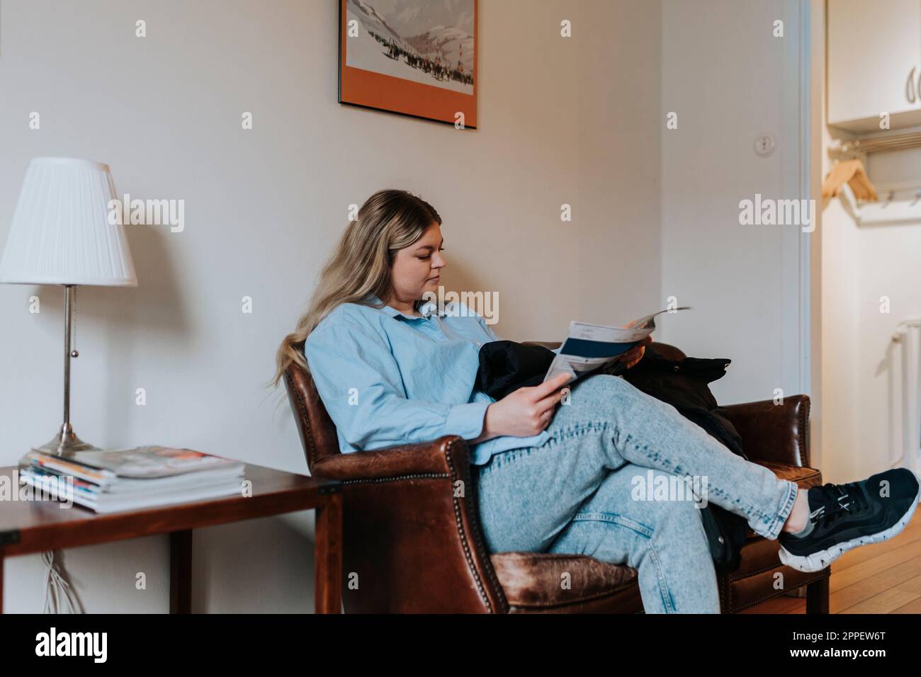 Female patient reading magazine in waiting room Stock Photo - Alamy