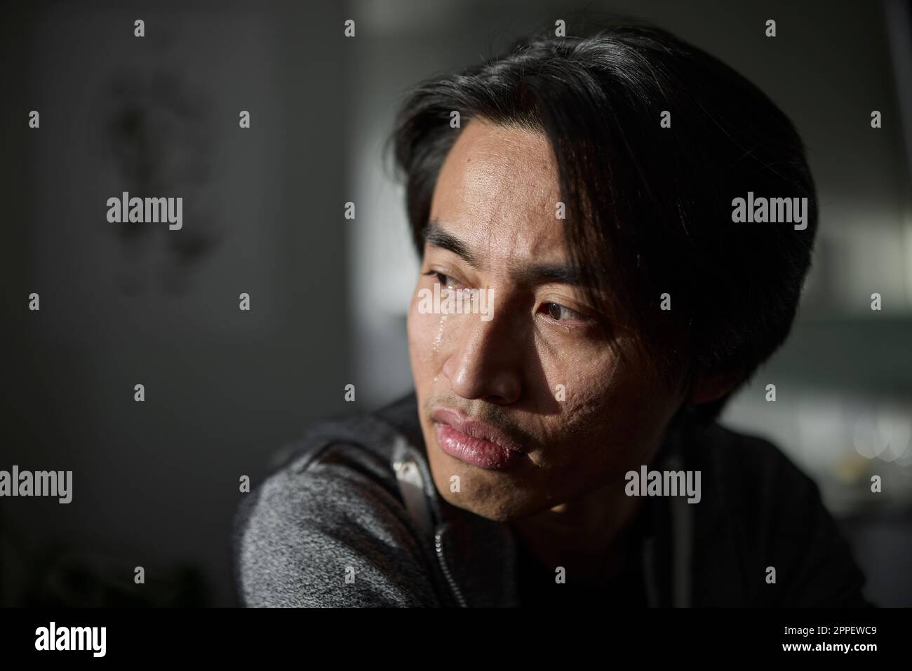 Portrait of crying man looking away Stock Photo - Alamy