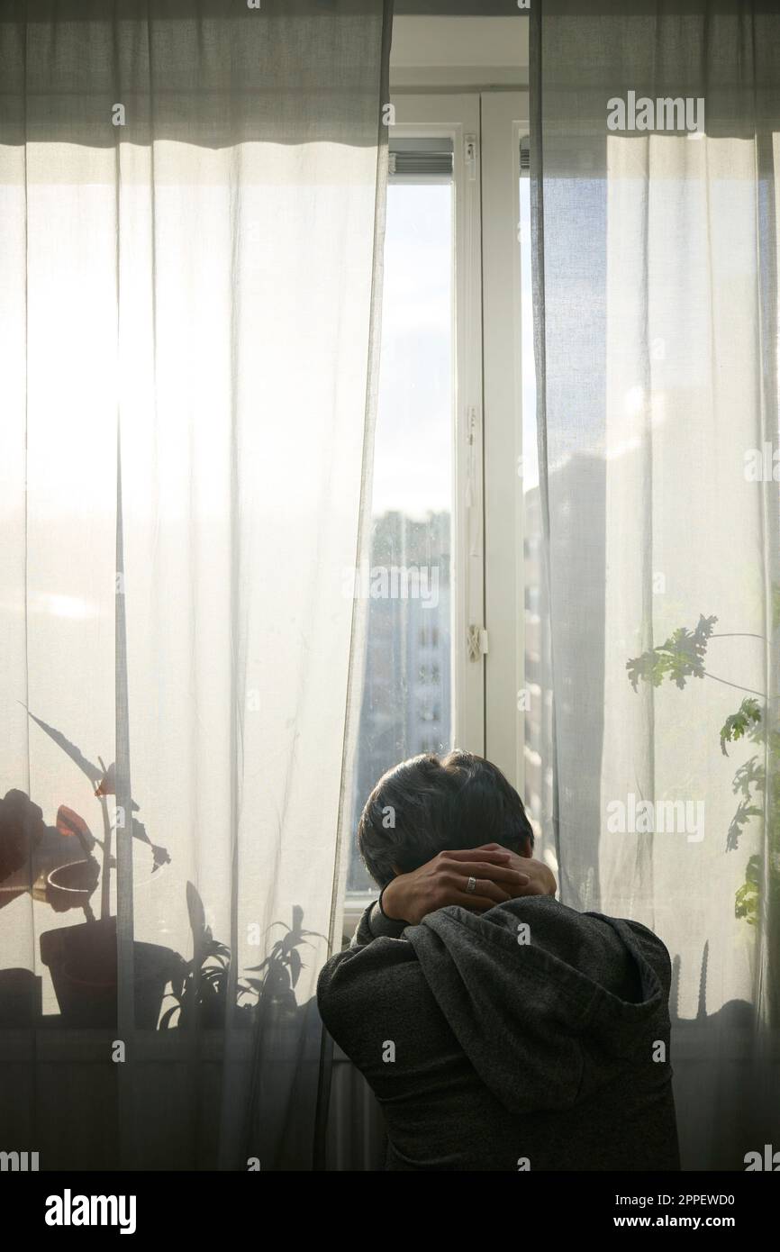 Rear view of person looking through window Stock Photo - Alamy