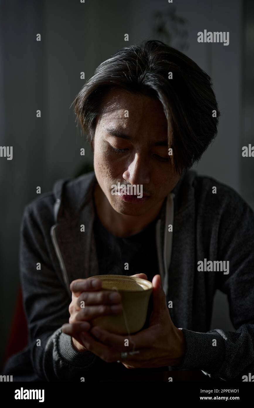 Sad man holding cup coffee hi-res stock photography and images - Alamy