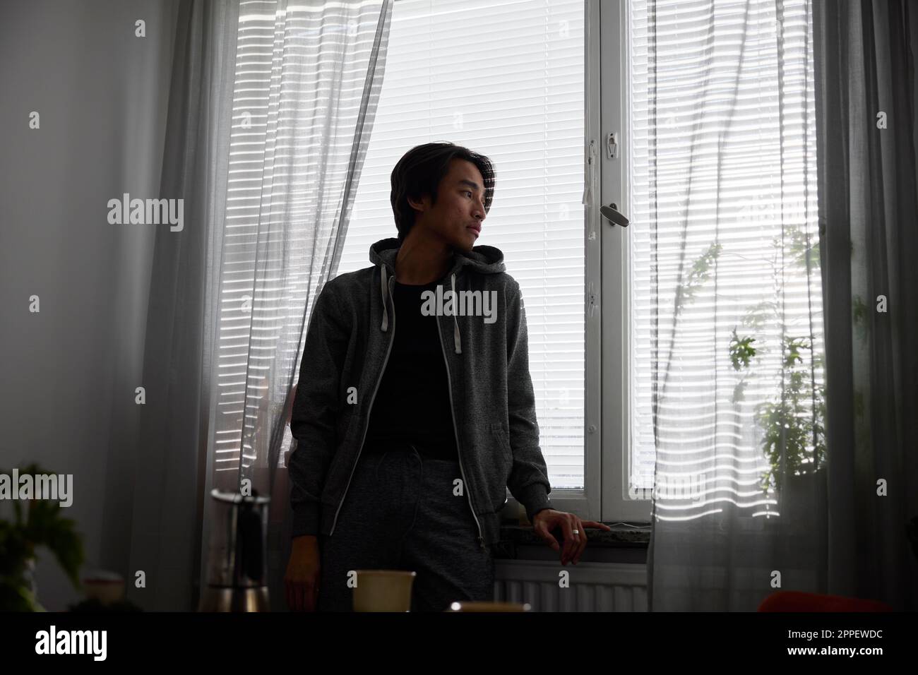 Man standing in front of window Stock Photo - Alamy