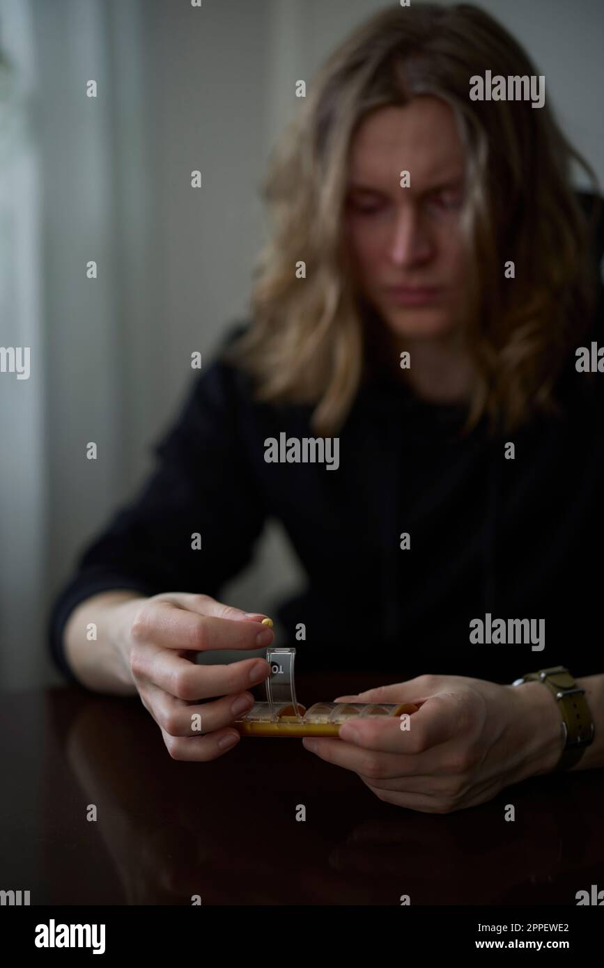 Sad woman holding pill box Stock Photo - Alamy