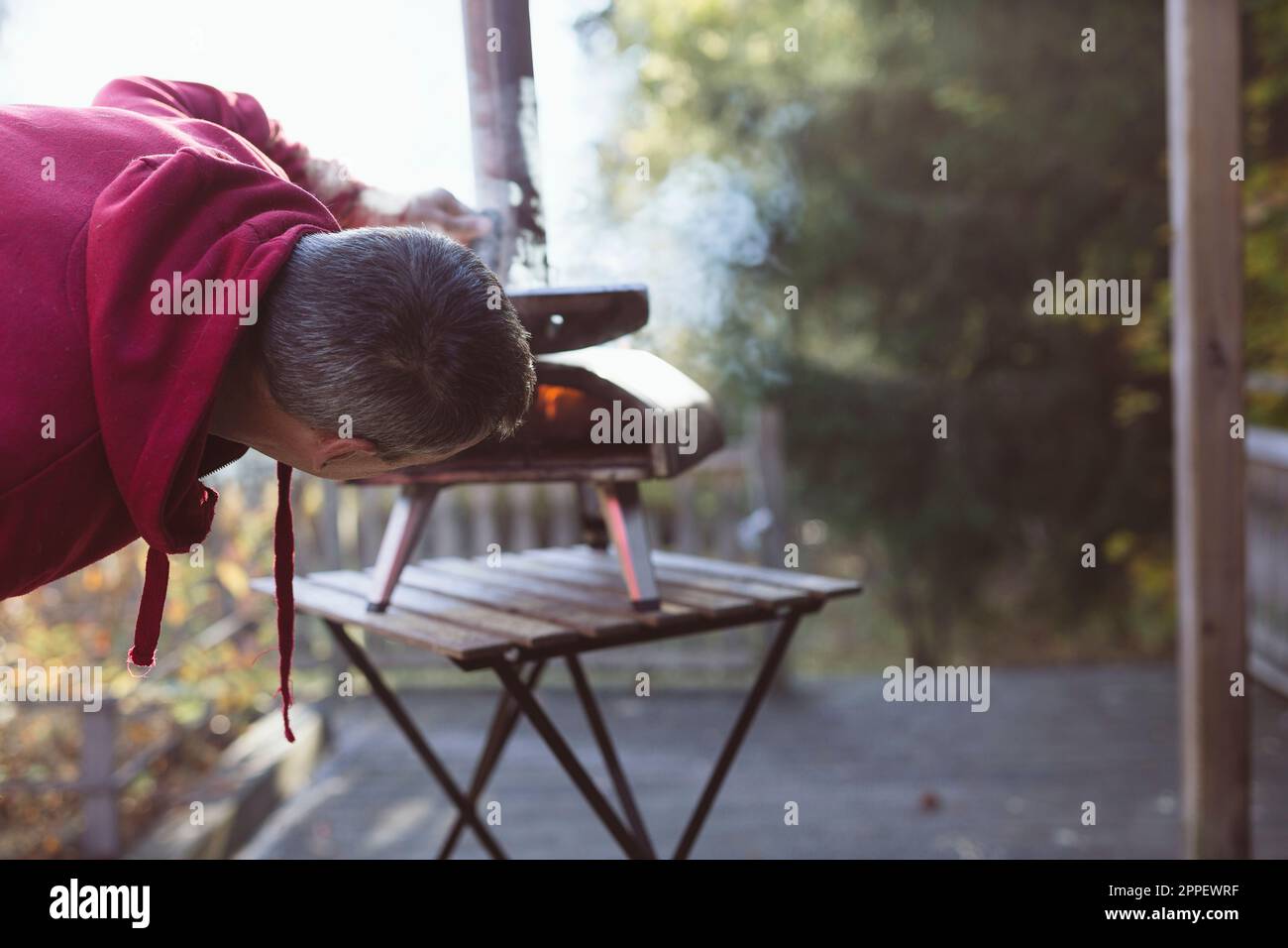 Man starting fire in outdoor pizza oven Stock Photo - Alamy