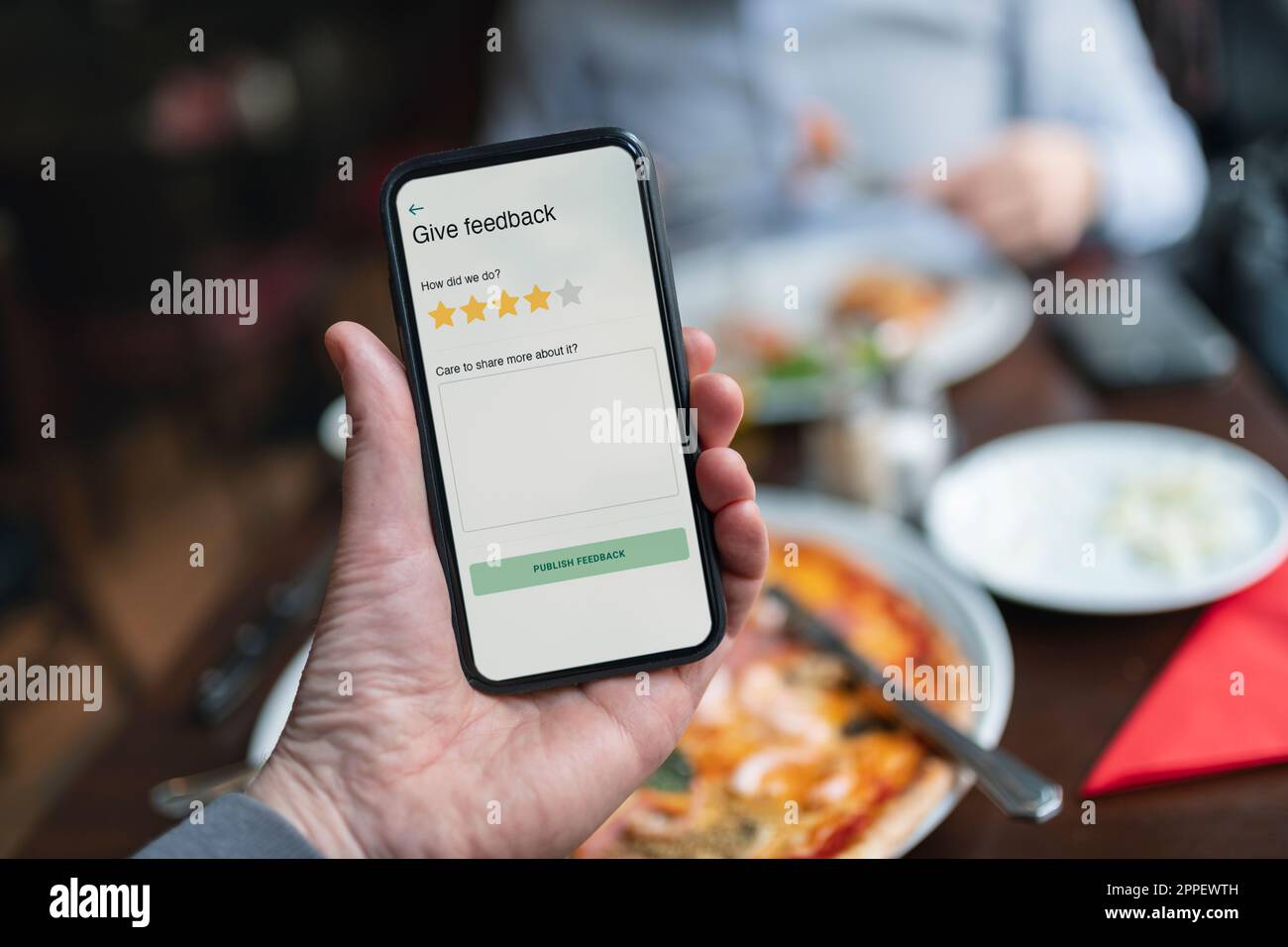 Person holding smart phone with restaurant rating app Stock Photo - Alamy