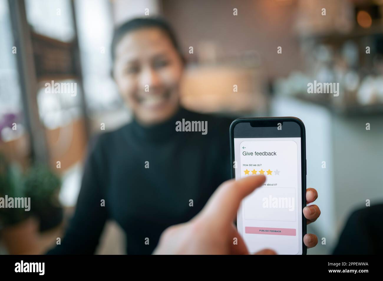 Person holding smart phone with rating app Stock Photo - Alamy
