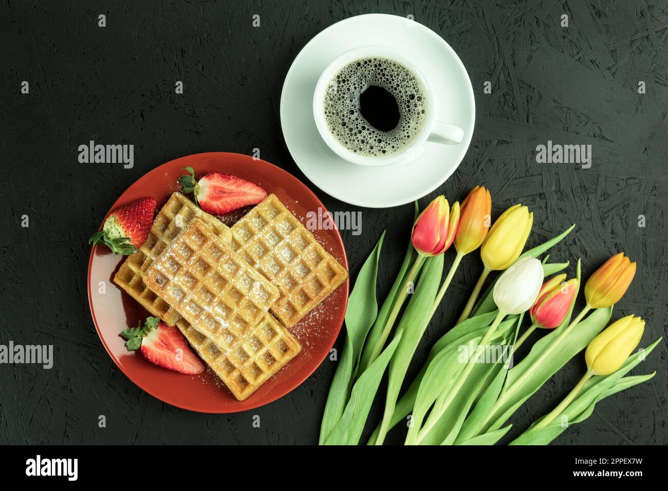 Fresh tulips and Belgian fruit waffles, top view. Tasty breakfast ...