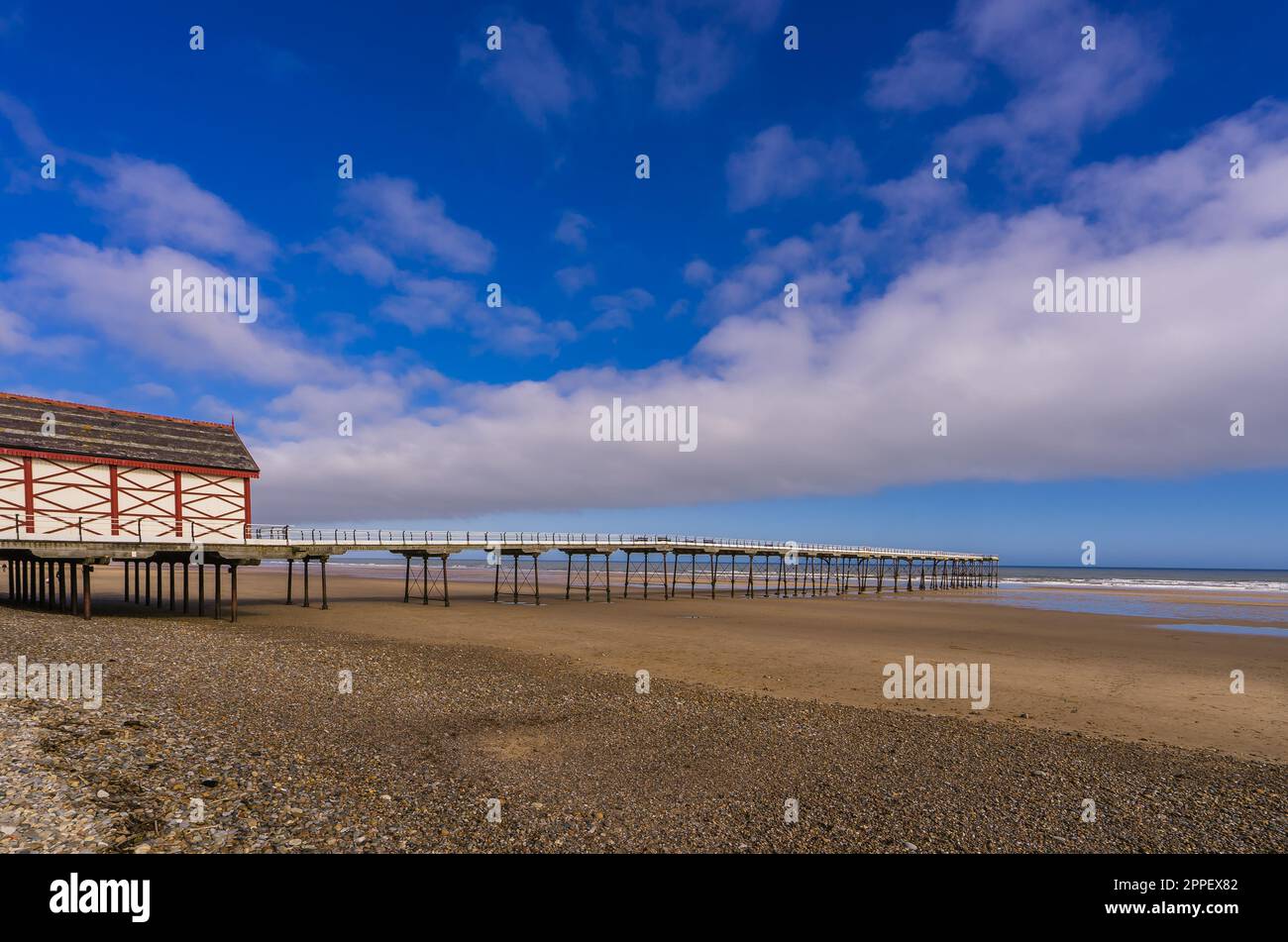 The old Victorian pier stretching out over the beach at low tide ...