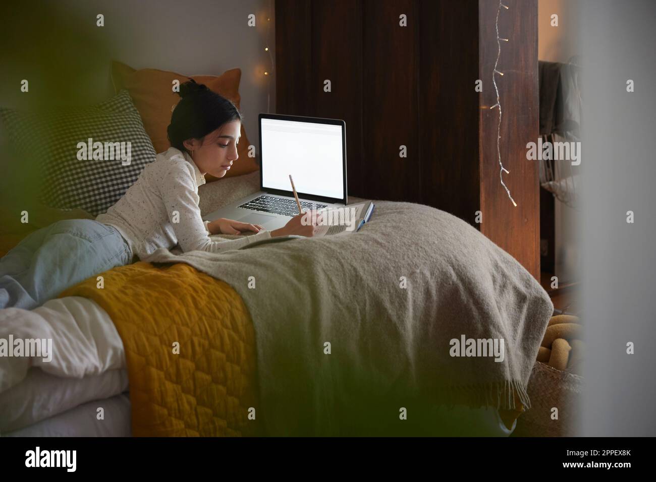 Girl doing homework with laptop in her bedroom Stock Photo - Alamy