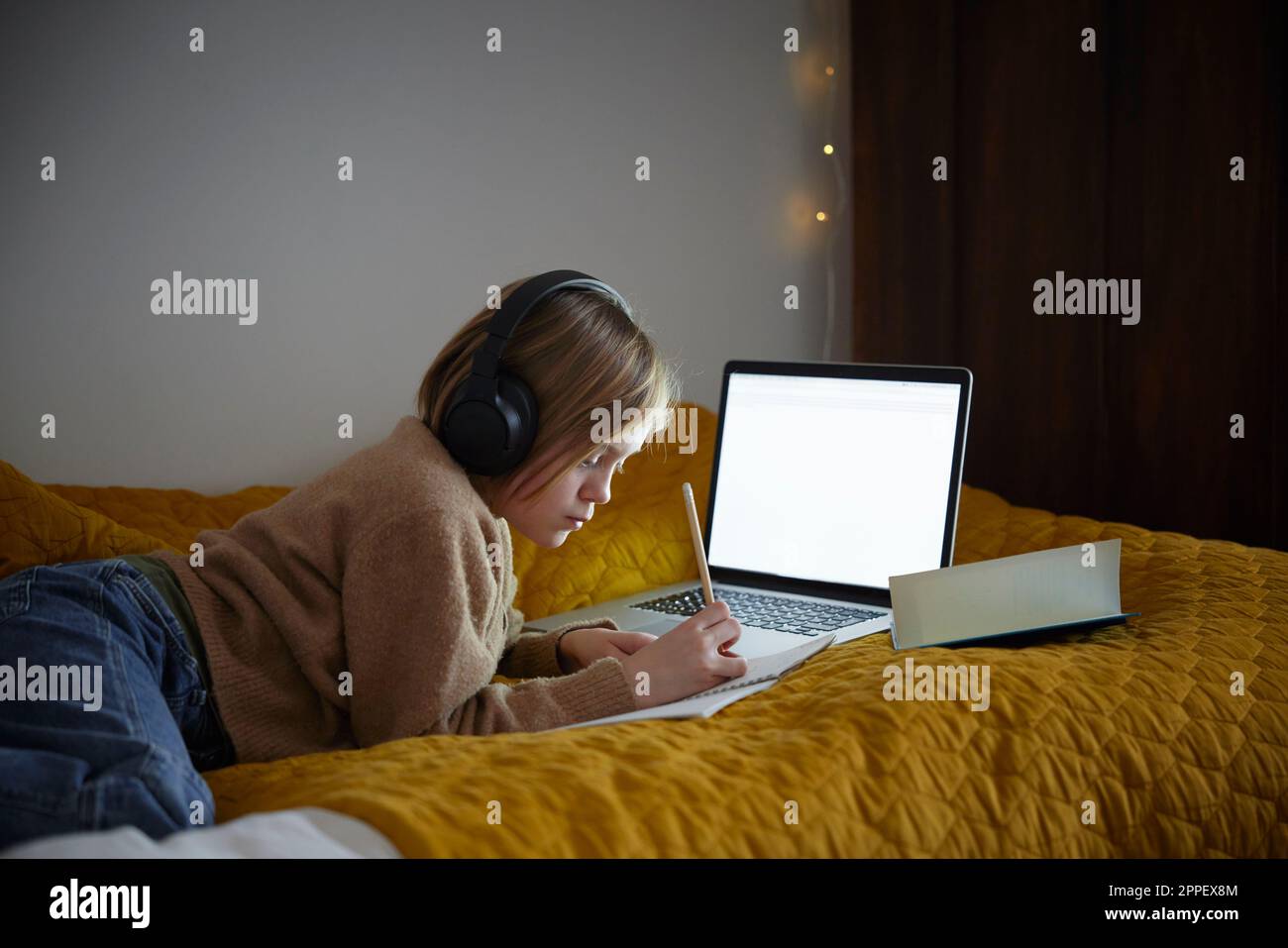 Girl doing homework with laptop in her bedroom Stock Photo - Alamy