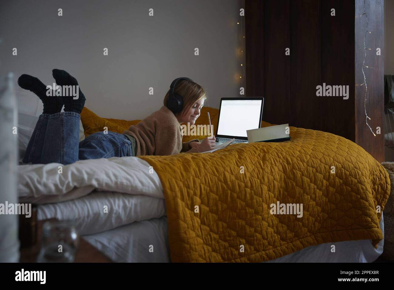 Girl doing homework with laptop in her bedroom Stock Photo - Alamy