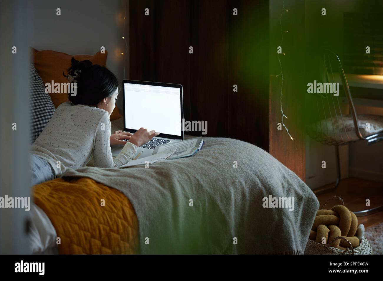 Girl doing homework with laptop in her bedroom Stock Photo - Alamy