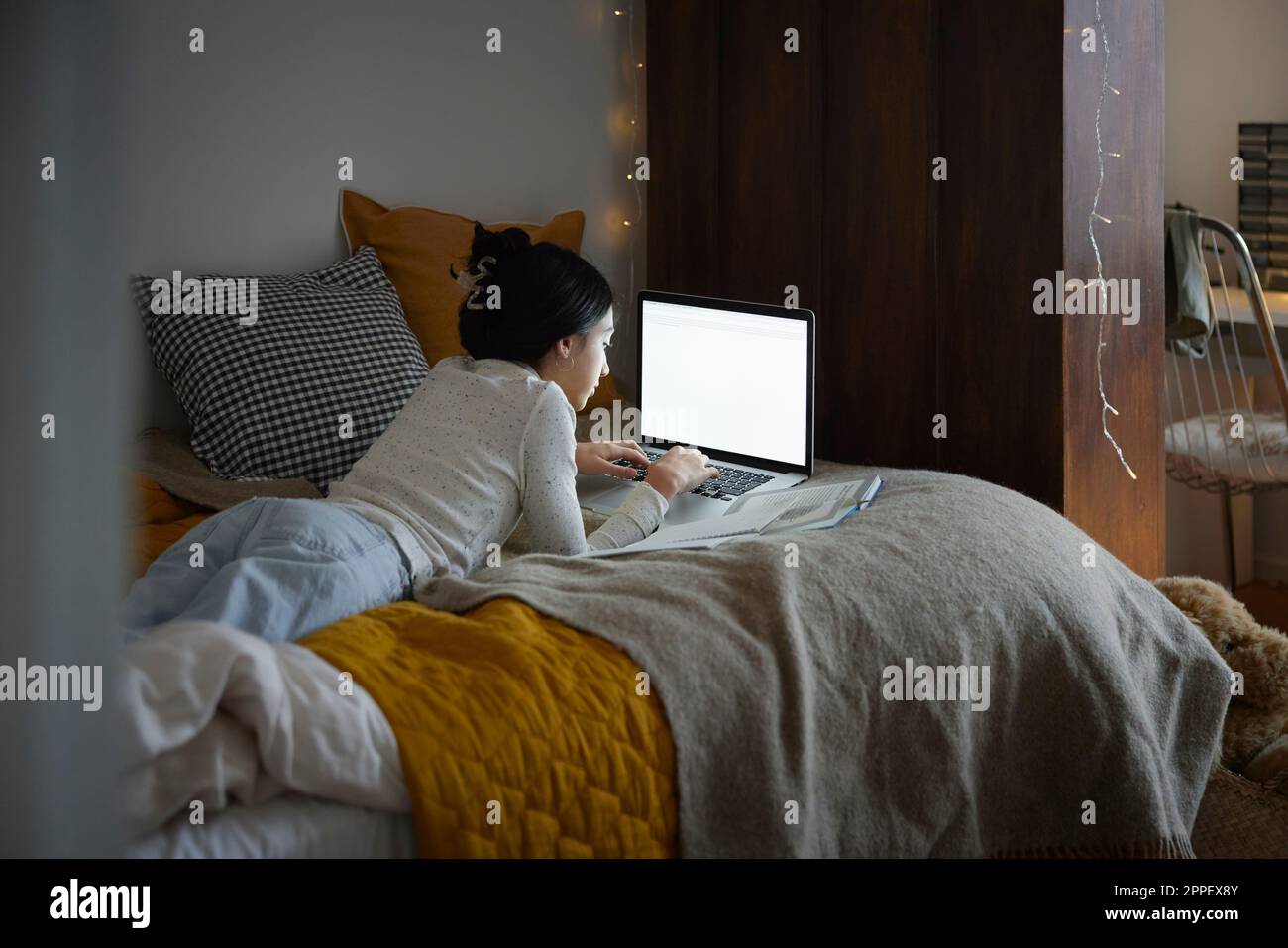 Girl doing homework with laptop in her bedroom Stock Photo - Alamy