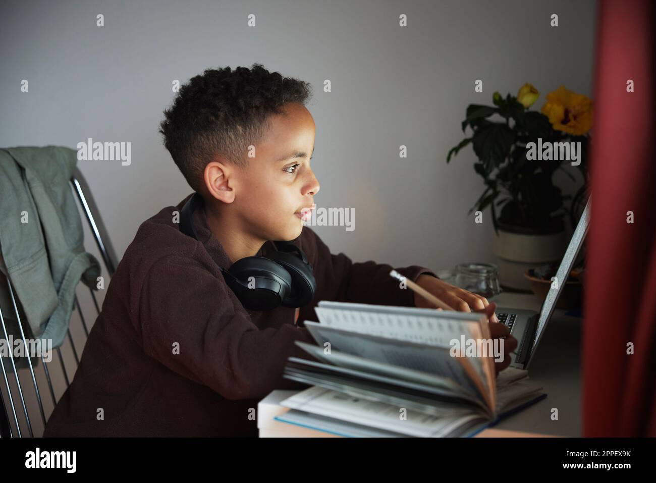 Boy doing homework with laptop Stock Photo - Alamy