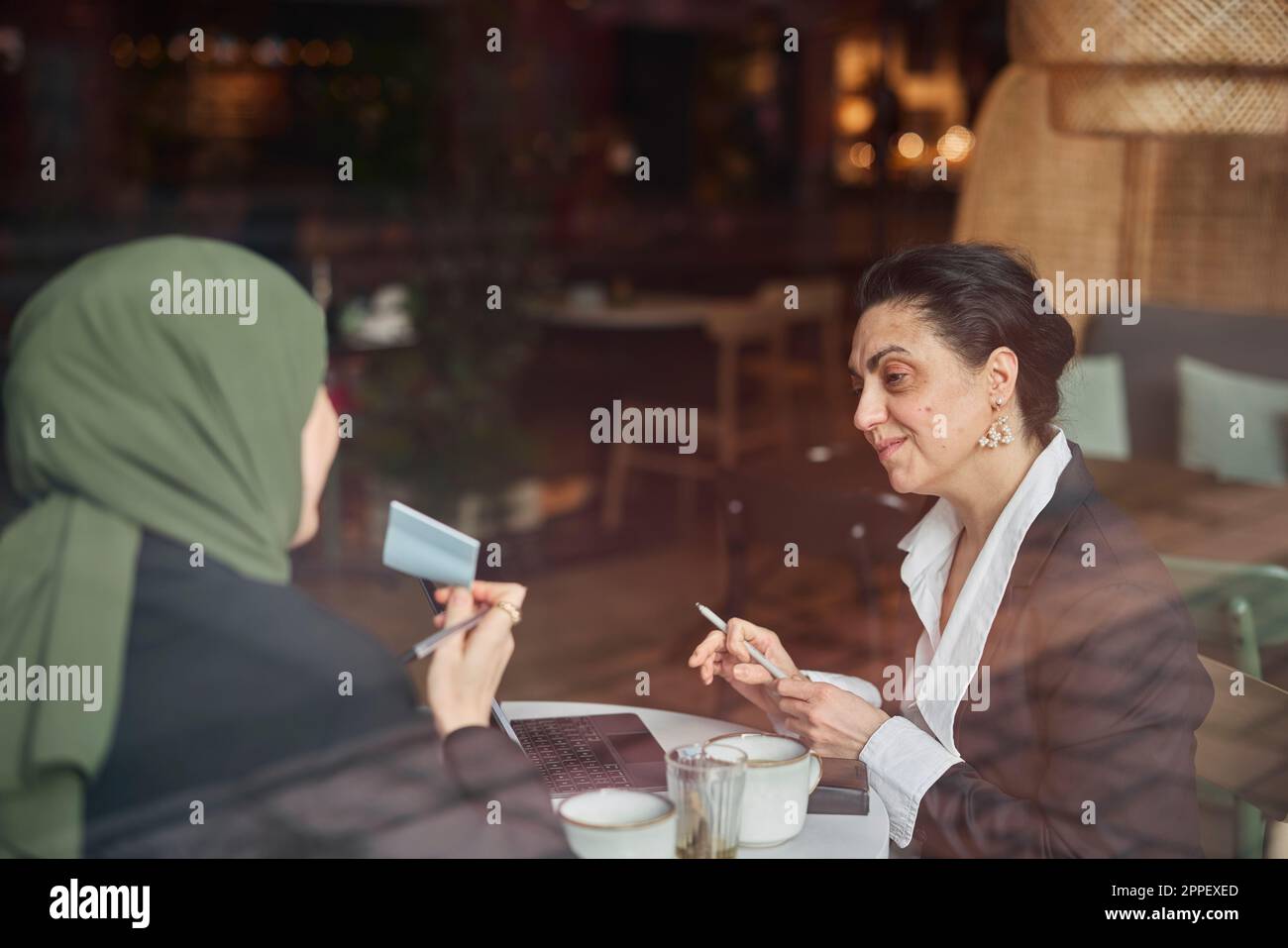 View through window of women in cafe Stock Photo - Alamy