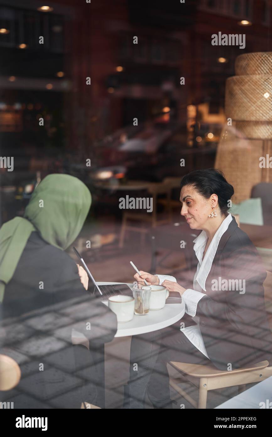 View through window of women in cafe Stock Photo - Alamy