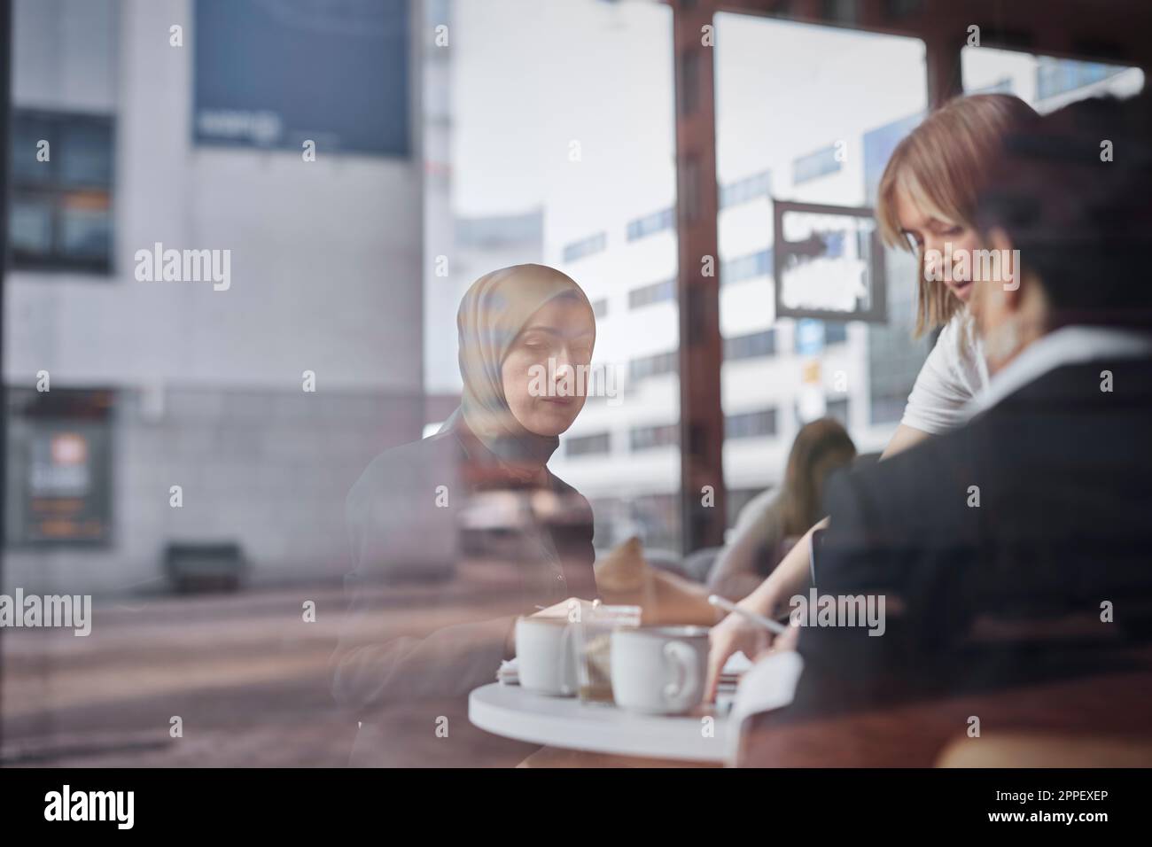 View through window of women in cafe Stock Photo - Alamy
