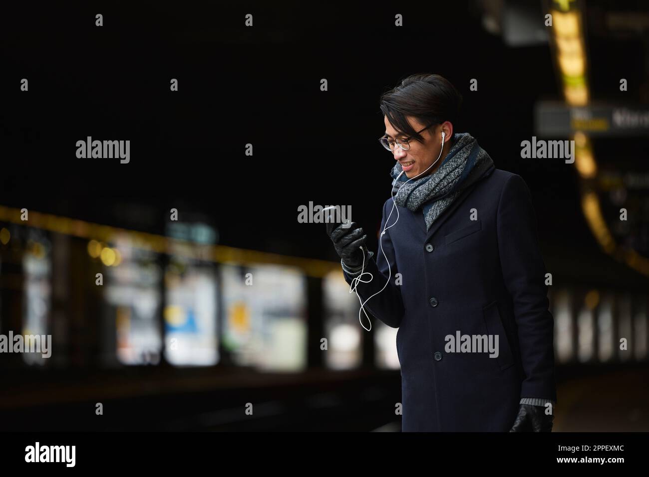 Smiling man standing at train platform Stock Photo - Alamy