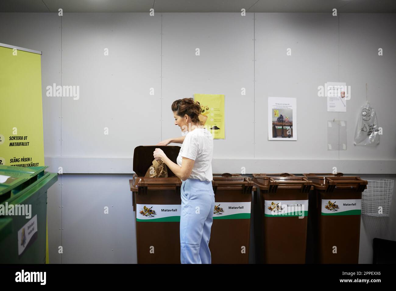 Woman putting waste in recycling bins Stock Photo - Alamy