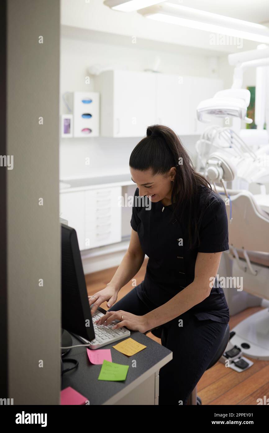 Female dentist writing in office Stock Photo - Alamy