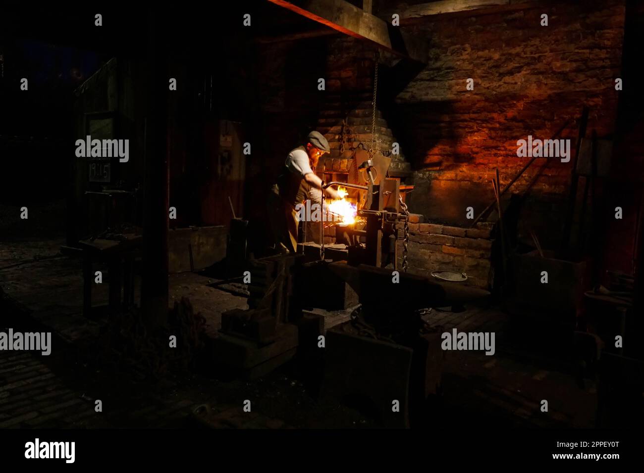 Chain maker hammering out a chain link causing sparks to fly, Red at ...