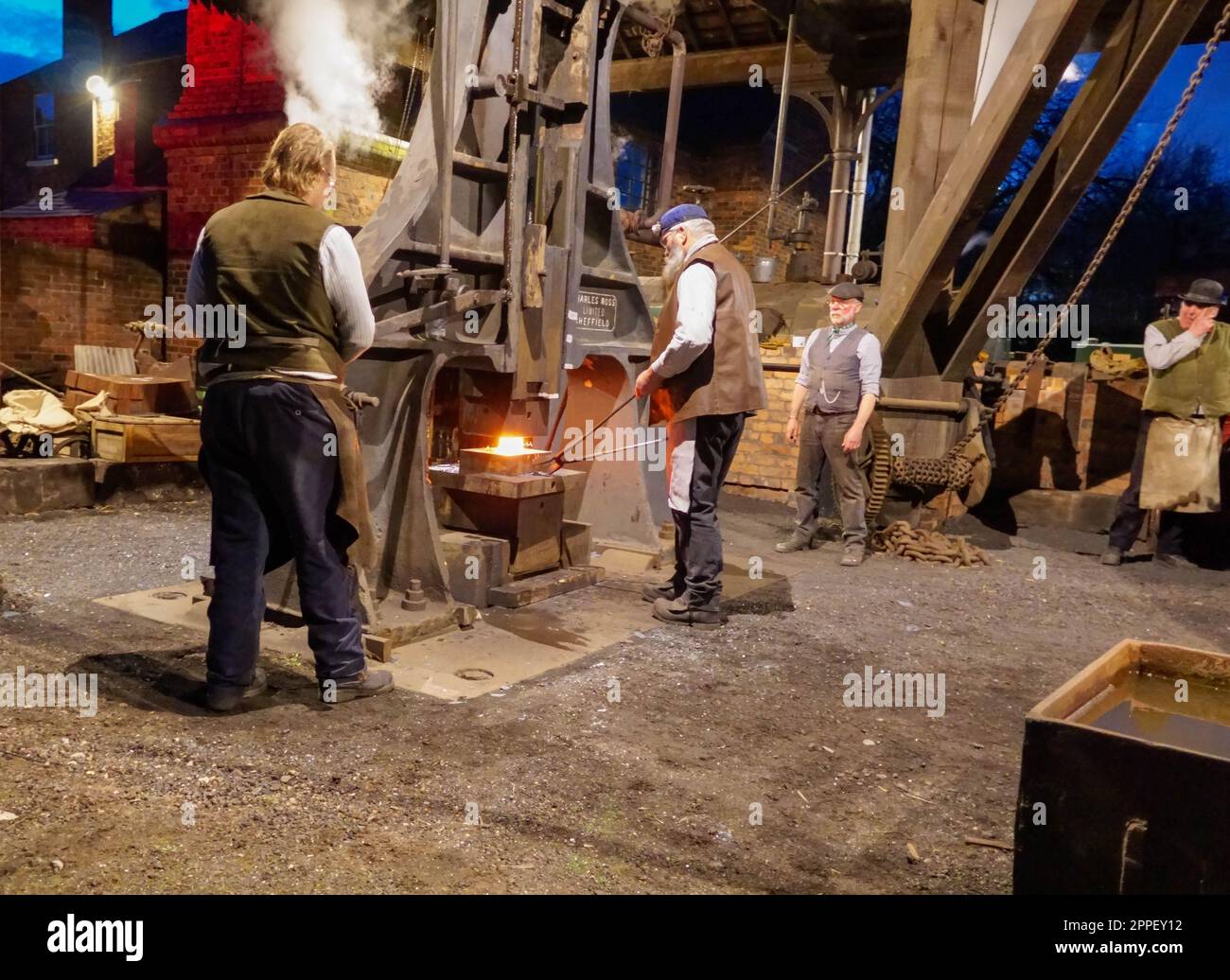 A white-hot ingot of metal being pressed by a volunteer using an Anchor ...
