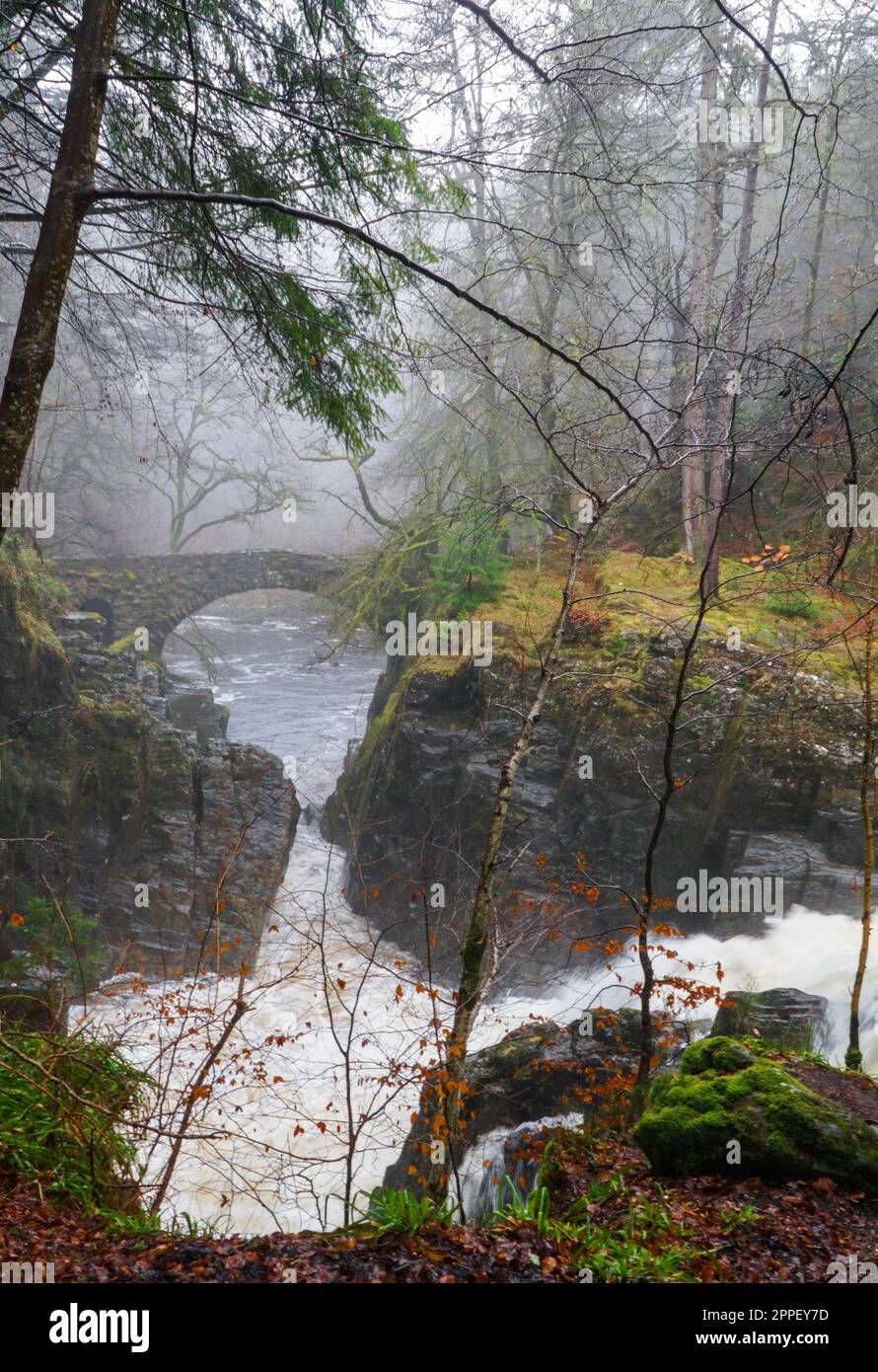 River Braan flowing beneath the single arch ancient footbridge at The ...