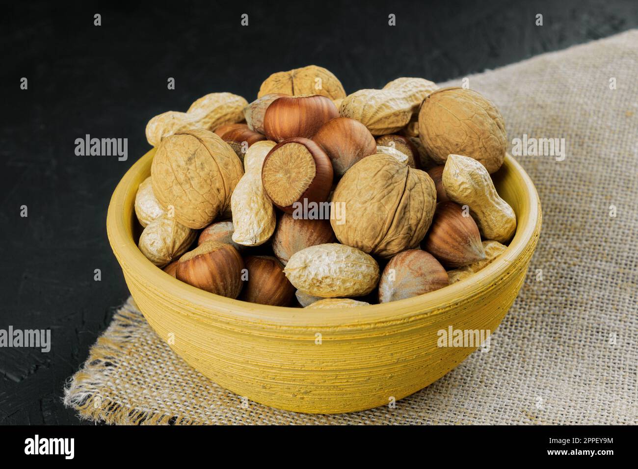 A mix of nuts in a shell, in a clay plate. A mixture of nuts on an old ...