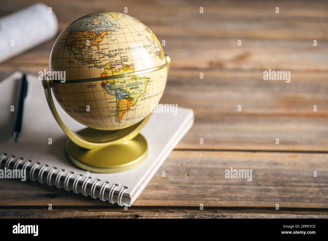 Travel composition with earth globe and notepad on blurred background ...