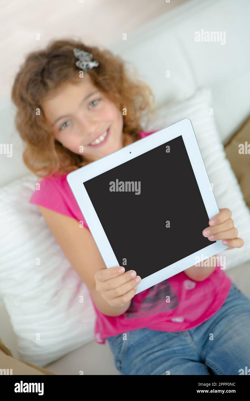 little girl is holding a tablet Stock Photo - Alamy