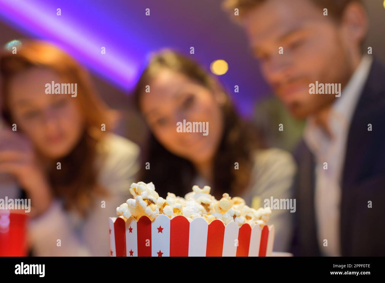 closeup on popcorn adults blurred in background Stock Photo - Alamy