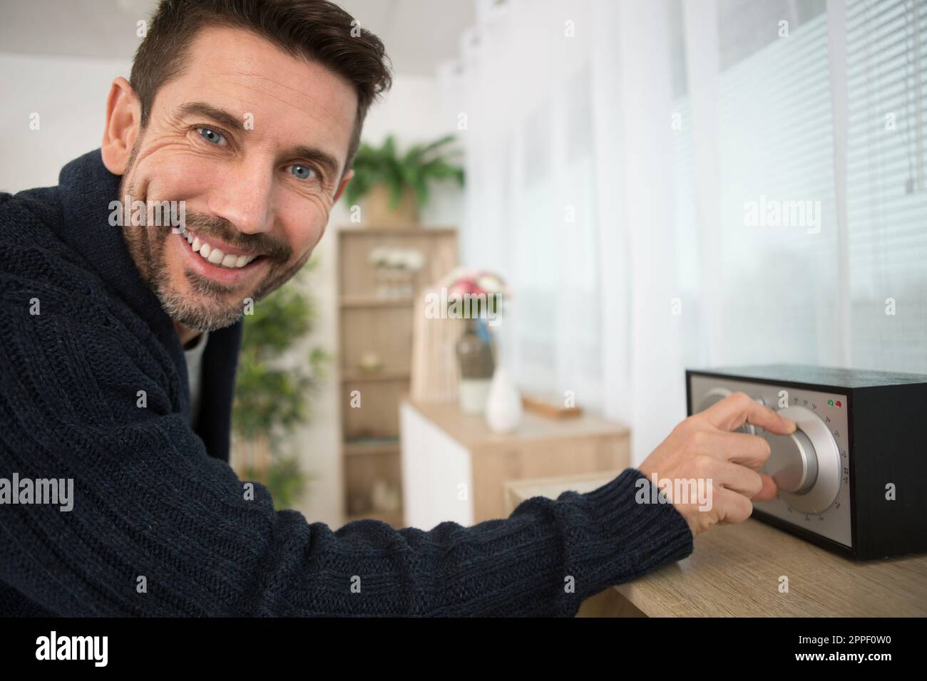 man turning dial on audio device Stock Photo - Alamy