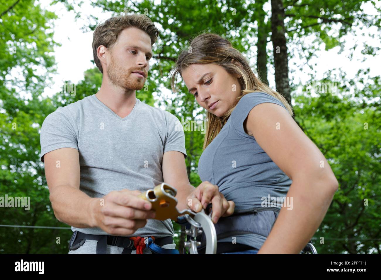 adventure worker giving instruction on harness safety to client Stock ...