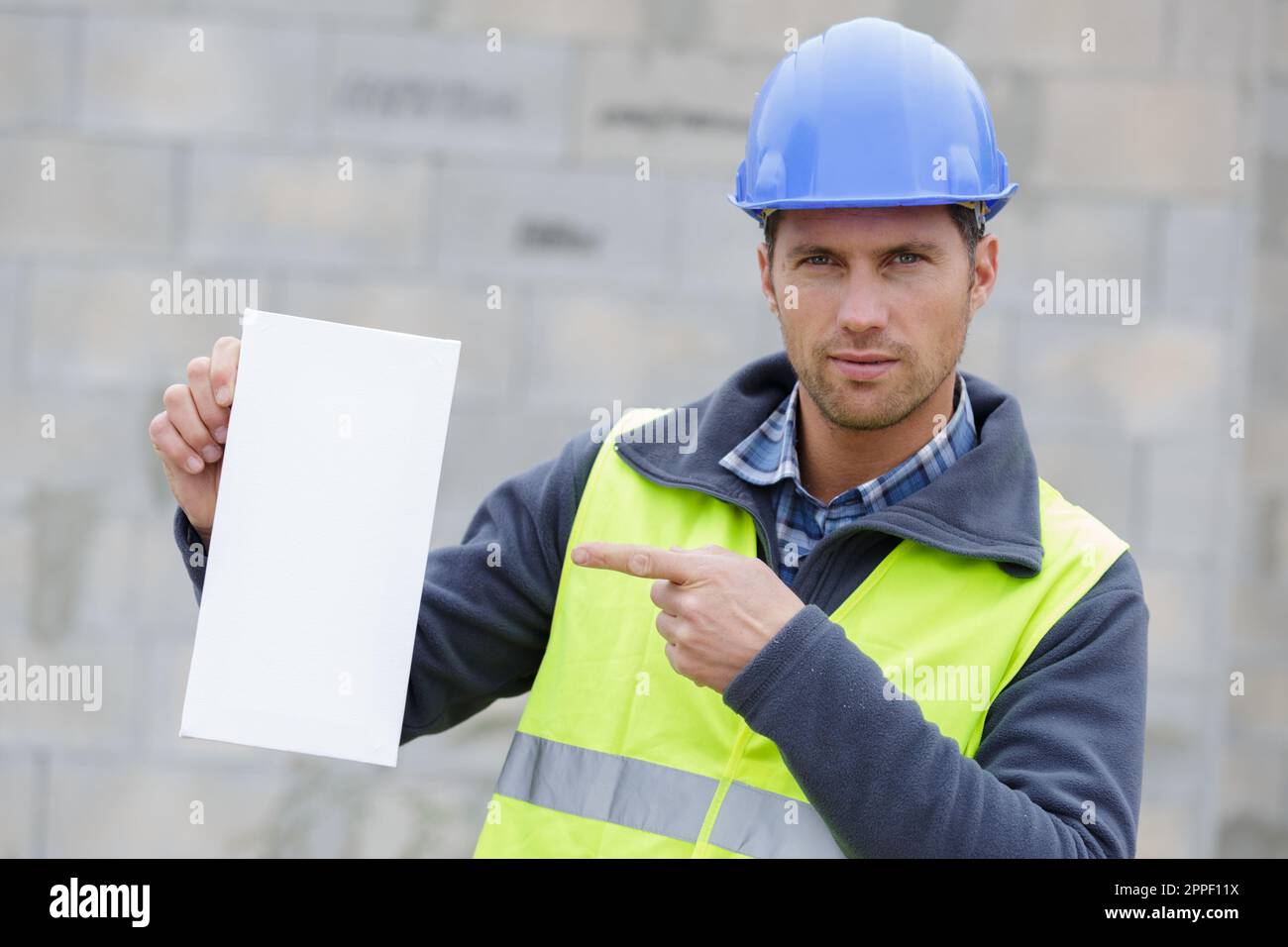 male builder pointing to a blank sign Stock Photo - Alamy