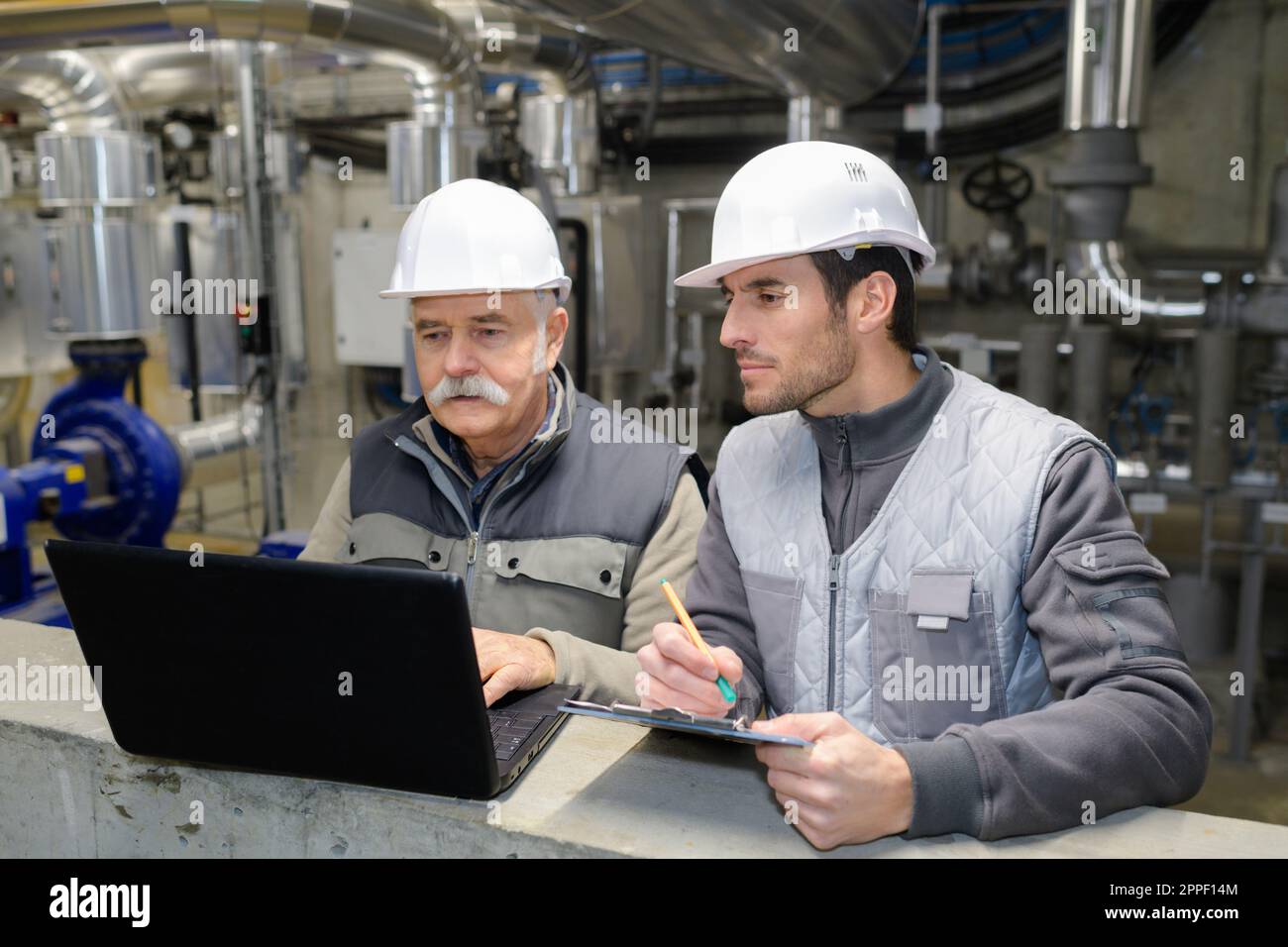 two man worker welding big steel piping in factory Stock Photo - Alamy
