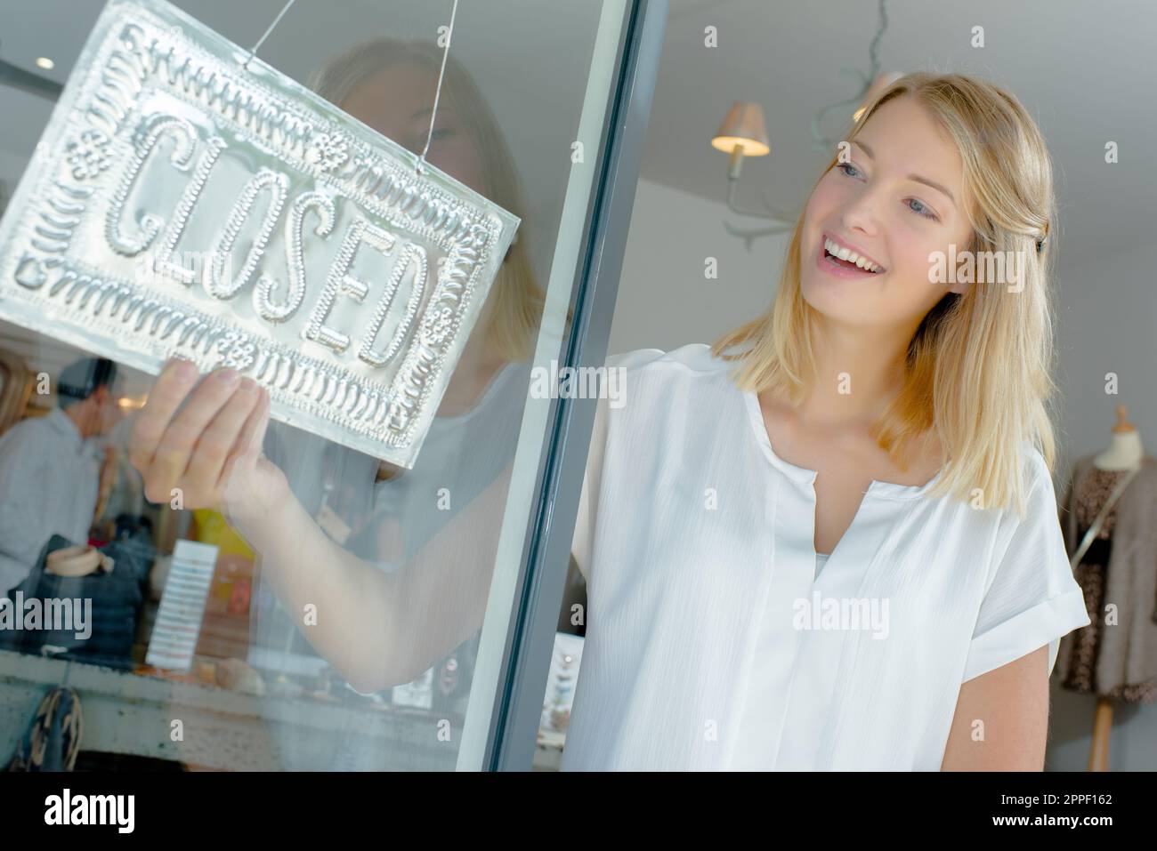 a shopkeeper is closing her shop Stock Photo - Alamy