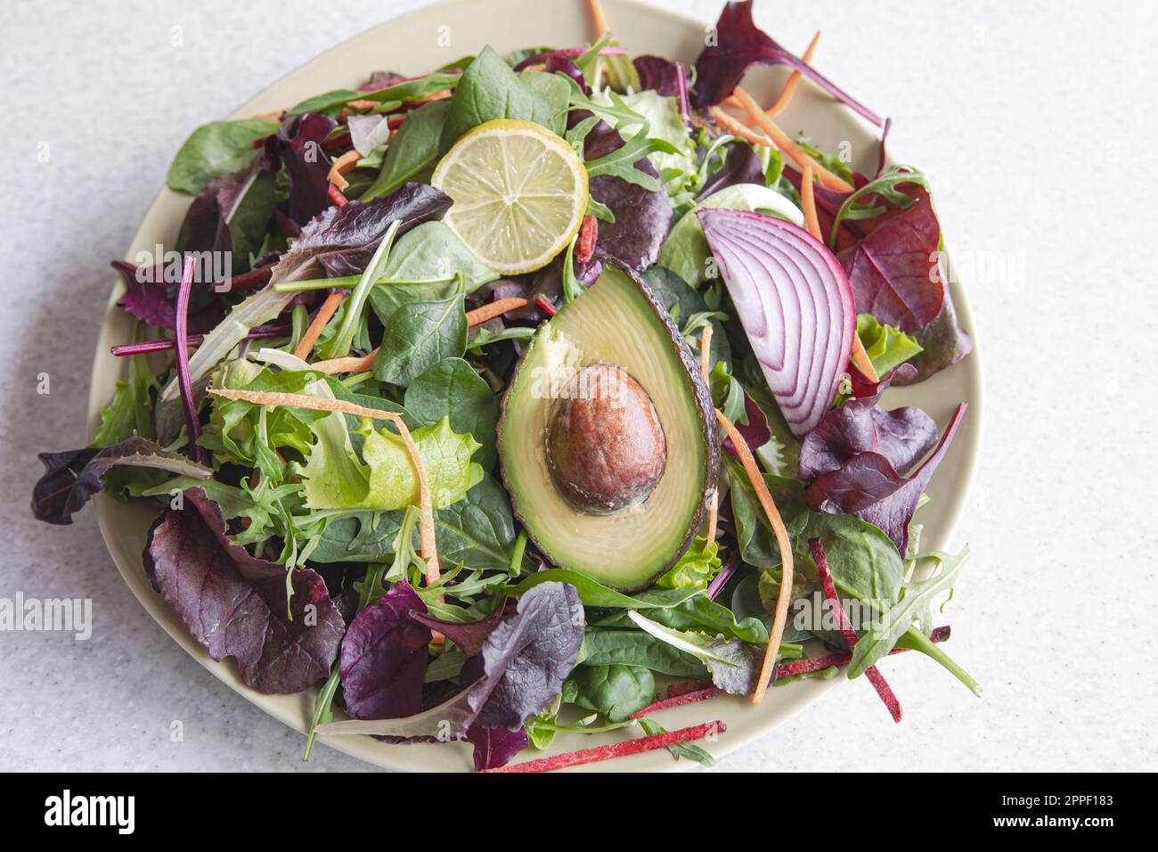 Salad of avocado and vegetables mixed greens lettuce leaves ready to ...