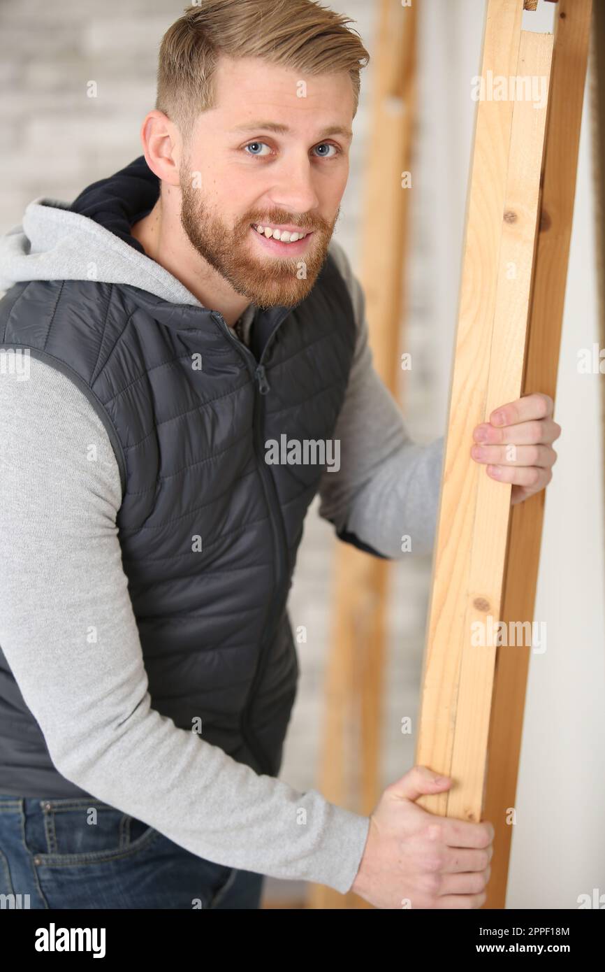 carpenter holding wooden support for studwork construction Stock Photo ...