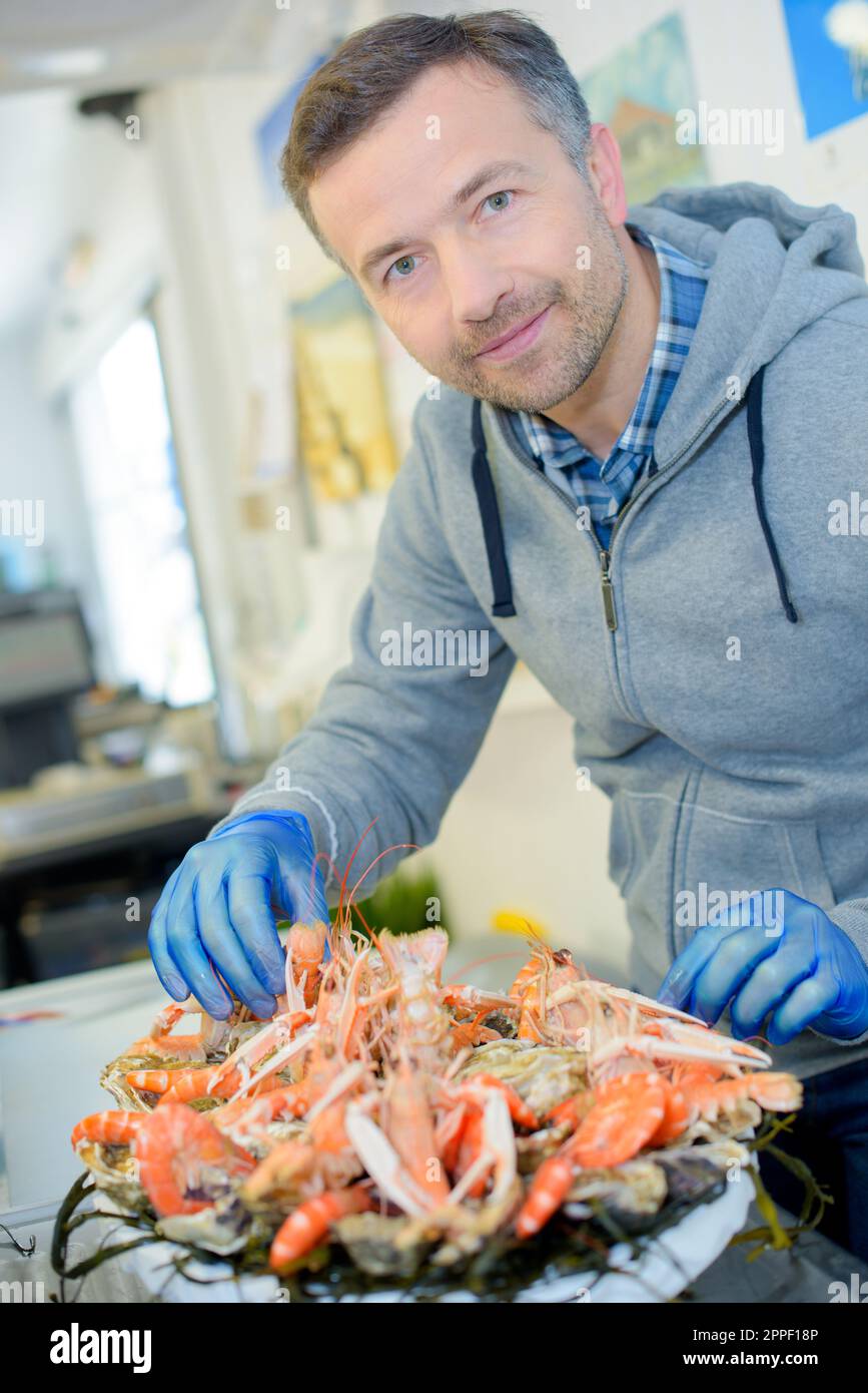 fishmonger with platter of prawns Stock Photo - Alamy