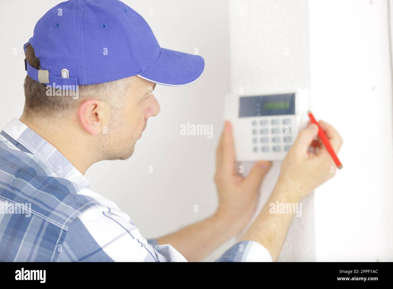 electrician during installation of wall device Stock Photo - Alamy