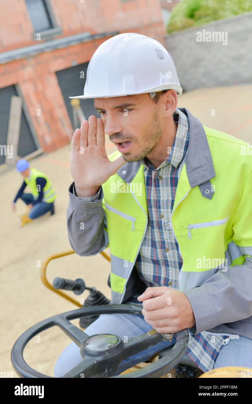 construction worker shouting to colleague from vehicle Stock Photo - Alamy