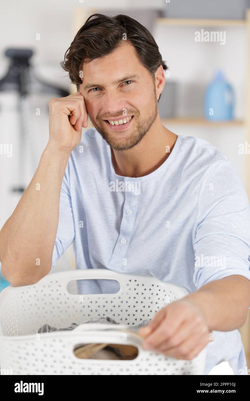 happy man taking clothes from drying rack Stock Photo - Alamy