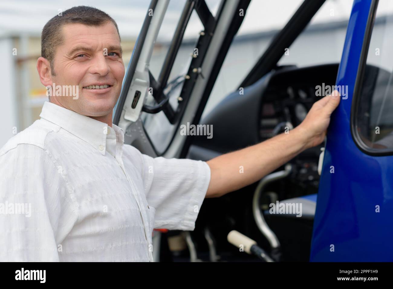 a helicopter pilot smiling at the camera Stock Photo - Alamy