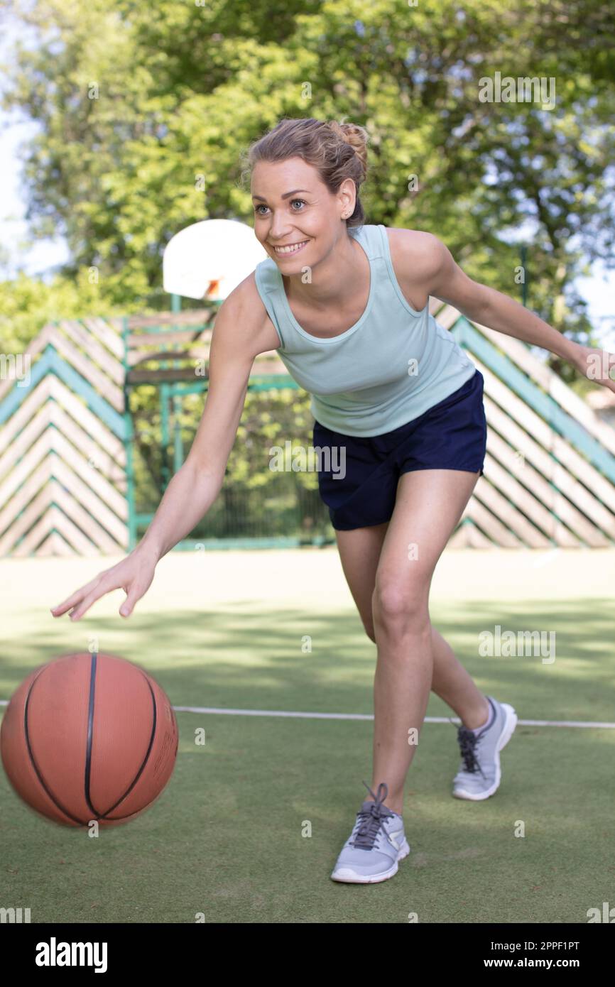 happy woman in jump throwing the basket ball Stock Photo - Alamy