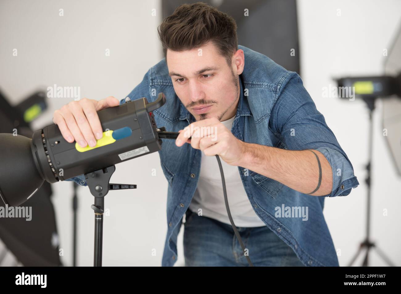 handsome male photographer fixing lights Stock Photo - Alamy